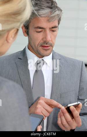 Business people exchanging phone numbers Stock Photo - Alamy
