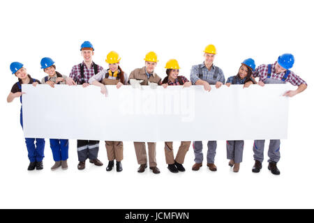 Large group of construction workers or workmen and women queuing up in ...