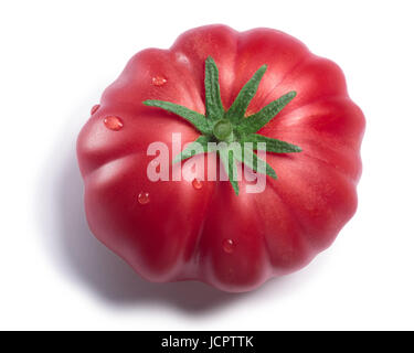 Pink ribbed heirloom tomato, imperfect, irregular shaped, with sepal ...