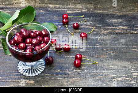 homemade sweet cherry compote in a glass with lemon on a wooden ...