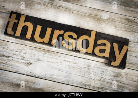 The word "Thursday" written in wooden letterpress type on a white ...