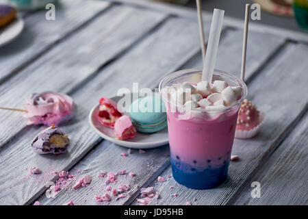 bubble tea in pink and blue color in a plastic Cup with a straw. The ...