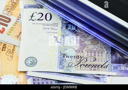 Handheld UV light over banknotes Stock Photo - Alamy