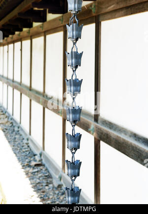 Close-up of Japanese rain chain. Lake's water surface with reflection ...