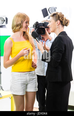 Reporter and cameraman film shoot actress interview on film set for ...