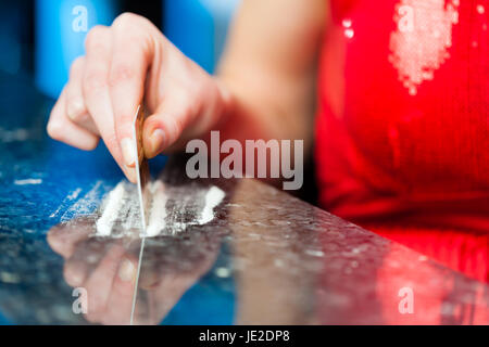 A young woman snorting a line of cocaine off a mirror through a Stock ...