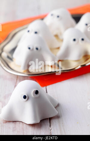 Ghost Halloween decorations or appetizers made with white pastry or ...