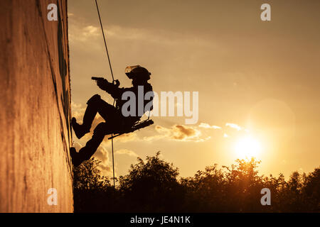 Silhouette of police officer during rope exercises with weapons Stock ...
