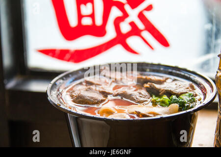 Spicy Chinese beef noodle soup with sliced beef shank and scallions ...