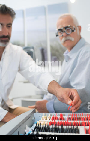 optician in surgery giving man eye test Stock Photo - Alamy