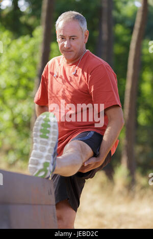 man stretches leg muscles before running Stock Photo - Alamy