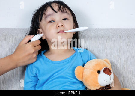 Asian Chinese little girl getting measurement for fever temperature at ...