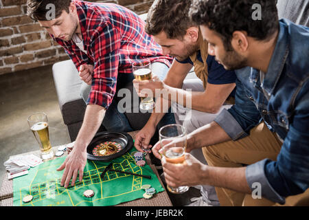 young men drinking beer and playing jenga game. young people having fun ...
