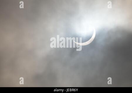 The solar eclipse is seen through the clouds at Queens University, Belfast, Northern Ireland ...