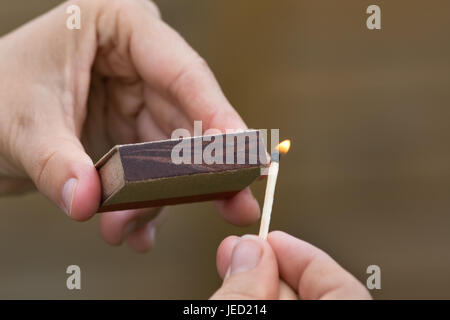hands striking a match on blurred background, closeup Stock Photo - Alamy