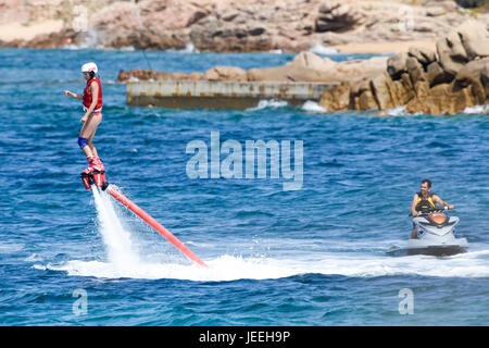 Silhouette of a fly board rider at sea and Parasailing in blue sky ...