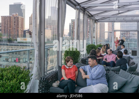 people at Ink48 Hotel rooftop bar enjoying corner perch on cushioned ...