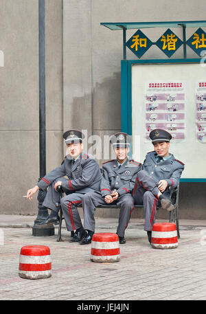 Chinese paramilitary police officers sit behind riot shields in a truck ...