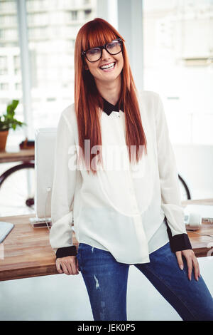 Smiling hipster businesswoman front of her desk Stock Photo - Alamy