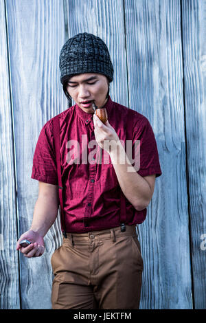 Hipster smoking pipe with a lighter Stock Photo - Alamy