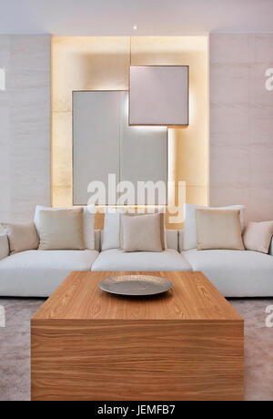 Comfortable white sofa and wooden coffee table with books on yellow ...