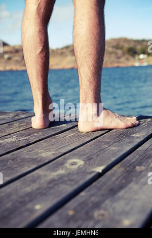 Man on jetty, low section Stock Photo - Alamy