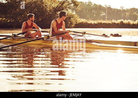 Two young men relaxing canoe ride on a quiet river Stock Photo - Alamy