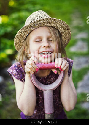 Happy blonde girl wearing a straw hat standing in a vast lavender field ...
