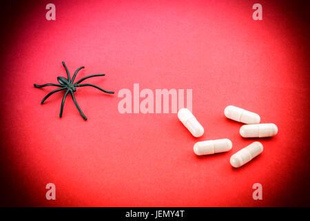 Spiders around capsules, concept phobia to medicines Stock Photo - Alamy