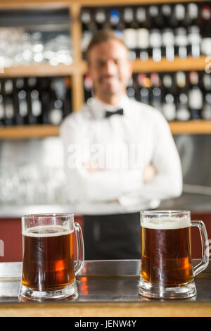 A bartender is filling a glass of beer on a tap Stock Photo - Alamy