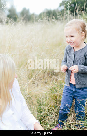 Two mischievous girls sitting together on the grass Stock Photo - Alamy
