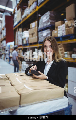 Female warehouse worker holding scanner, scanning the barcodes on ...