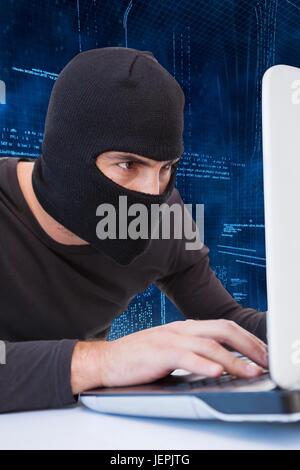 Masked man using laptop Stock Photo - Alamy