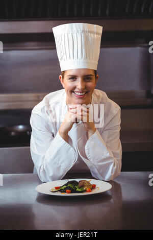 Chef leaning on the counter with a dish Stock Photo - Alamy