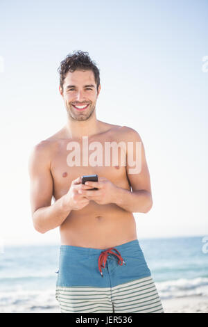 Smiling fit man using smartphone Stock Photo - Alamy