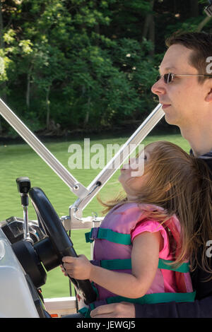 Father and young daughter driving a boat, Noxon, Montana, USA Stock ...