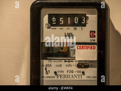 An old style mechanical electricity meter alongside a row of plug in ...