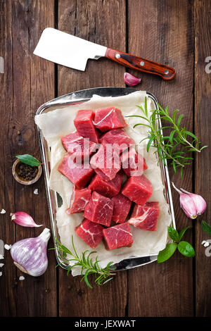 Raw beef fillet with onion and pepper ready for cooking on wooden table ...