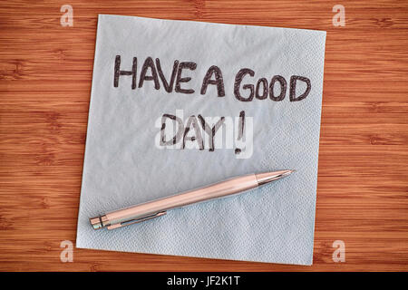 Have a nice day! Handwriting on a napkin with cup of coffee and pen ...