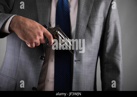 Man pulling out gun from his pocket Stock Photo - Alamy