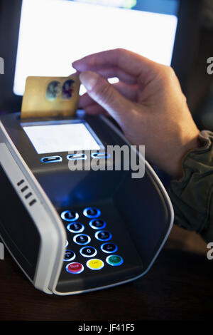 Hand putting bank card into card reader Stock Photo - Alamy
