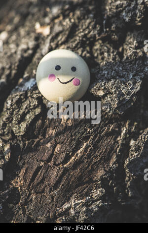 Smile icon miniature on tree twig Stock Photo - Alamy