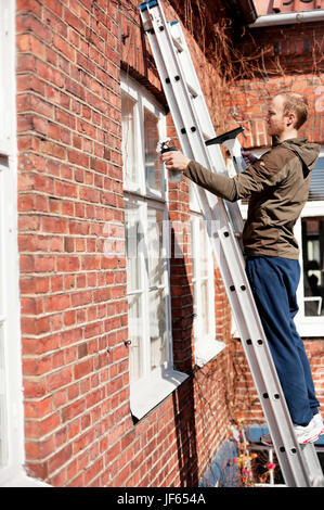Man on ladder cleaning window Stock Photo - Alamy