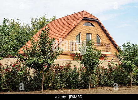 Facade of a house with a tiled roof and small windows Stock Photo - Alamy