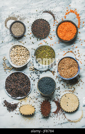 Organic uncooked scattered buckwheat grain in a bowl and wooden scoop ...