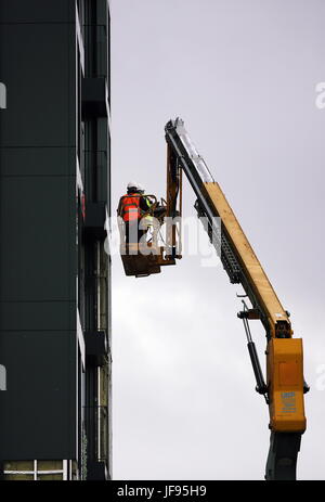 Workers on a cherry picker remove cladding panels from Kennedy Gardens ...