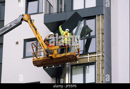Workers on a cherry picker remove cladding panels from Kennedy Gardens ...