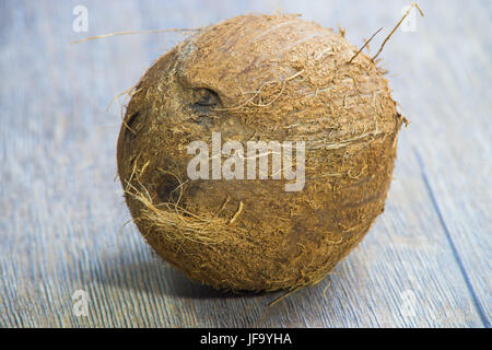 Coconut on wooden table on bright blurred background Stock Photo - Alamy