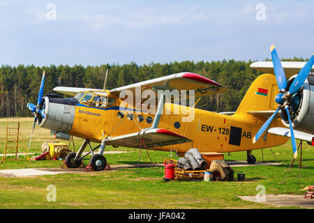 A vintage single-engine aircraft with a propeller flying over a farm ...