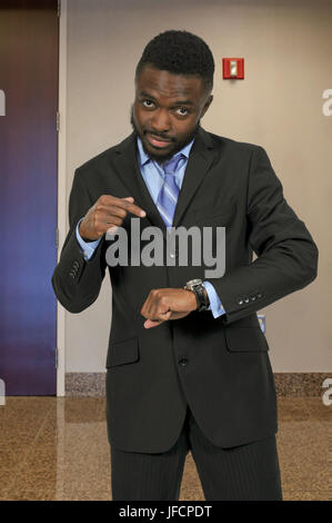 Professional man pointing finger at wristwatch natural background ...